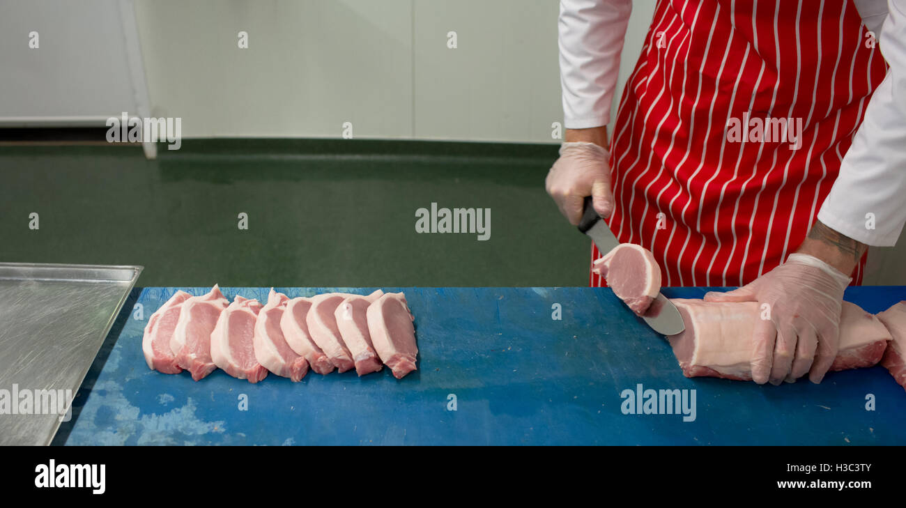 Mid section of butcher slicing meat Stock Photo - Alamy