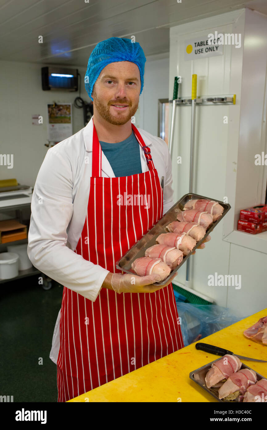 Butcher holding a tray of chicken and steak rolls Stock Photo - Alamy