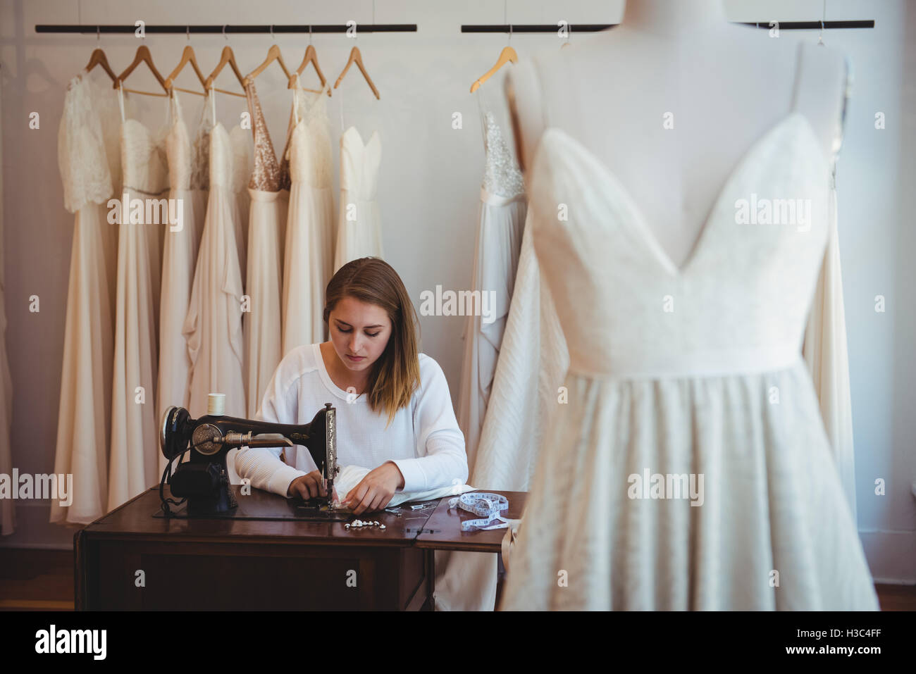 Female dressmaker sewing in the studio Stock Photo - Alamy