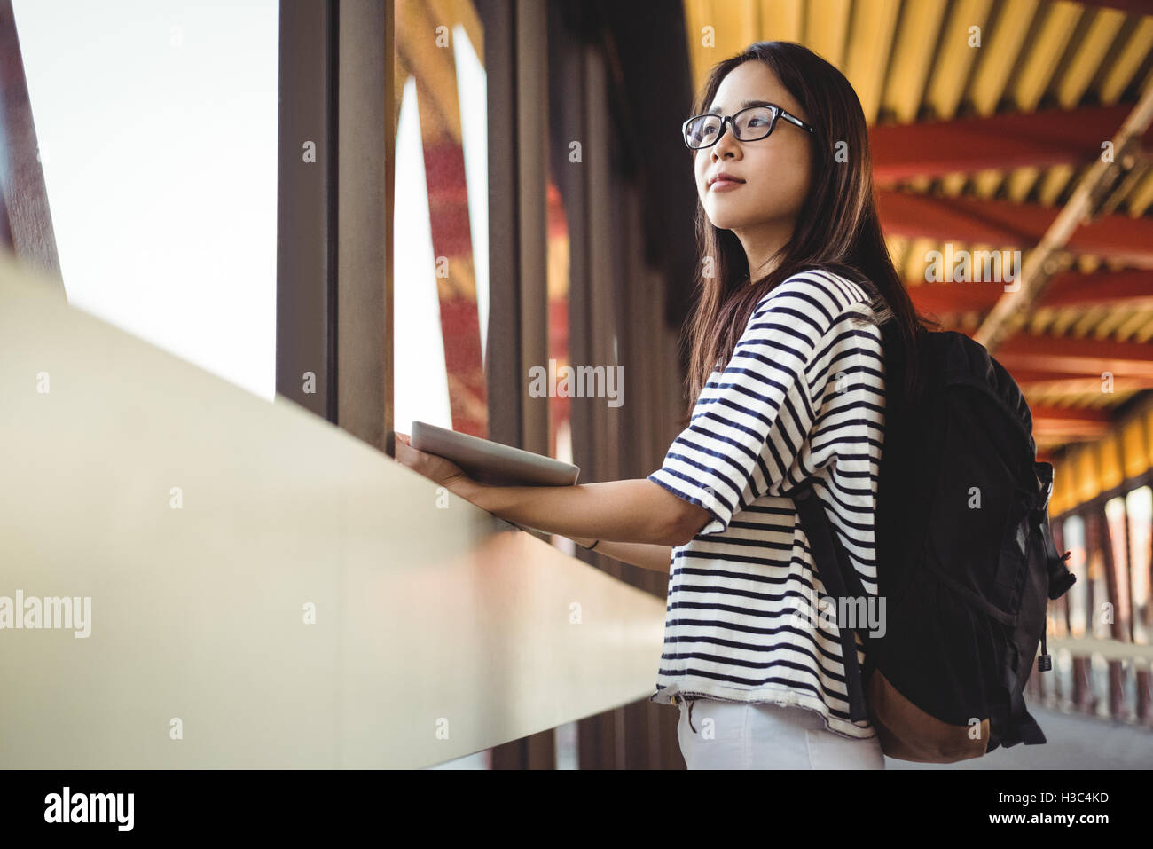 Young woman looking through window Stock Photo - Alamy