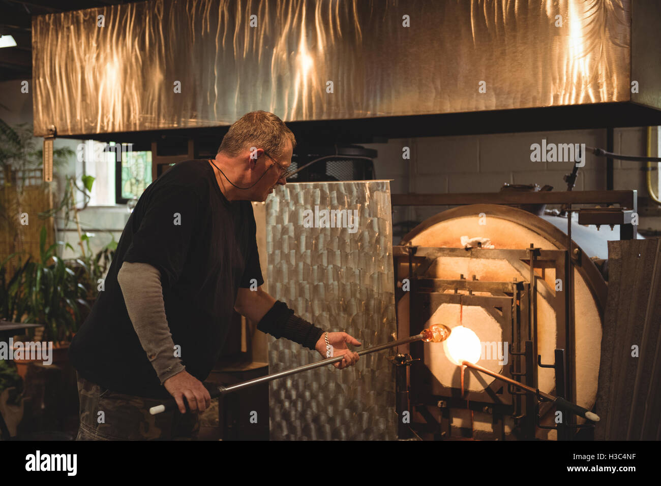 Glassblower heating a glass in furnace Stock Photo - Alamy