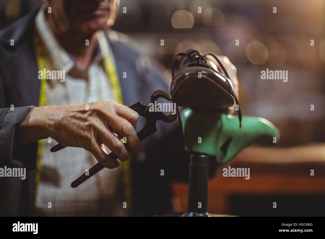 Shoemaker repairing a shoe Stock Photo - Alamy