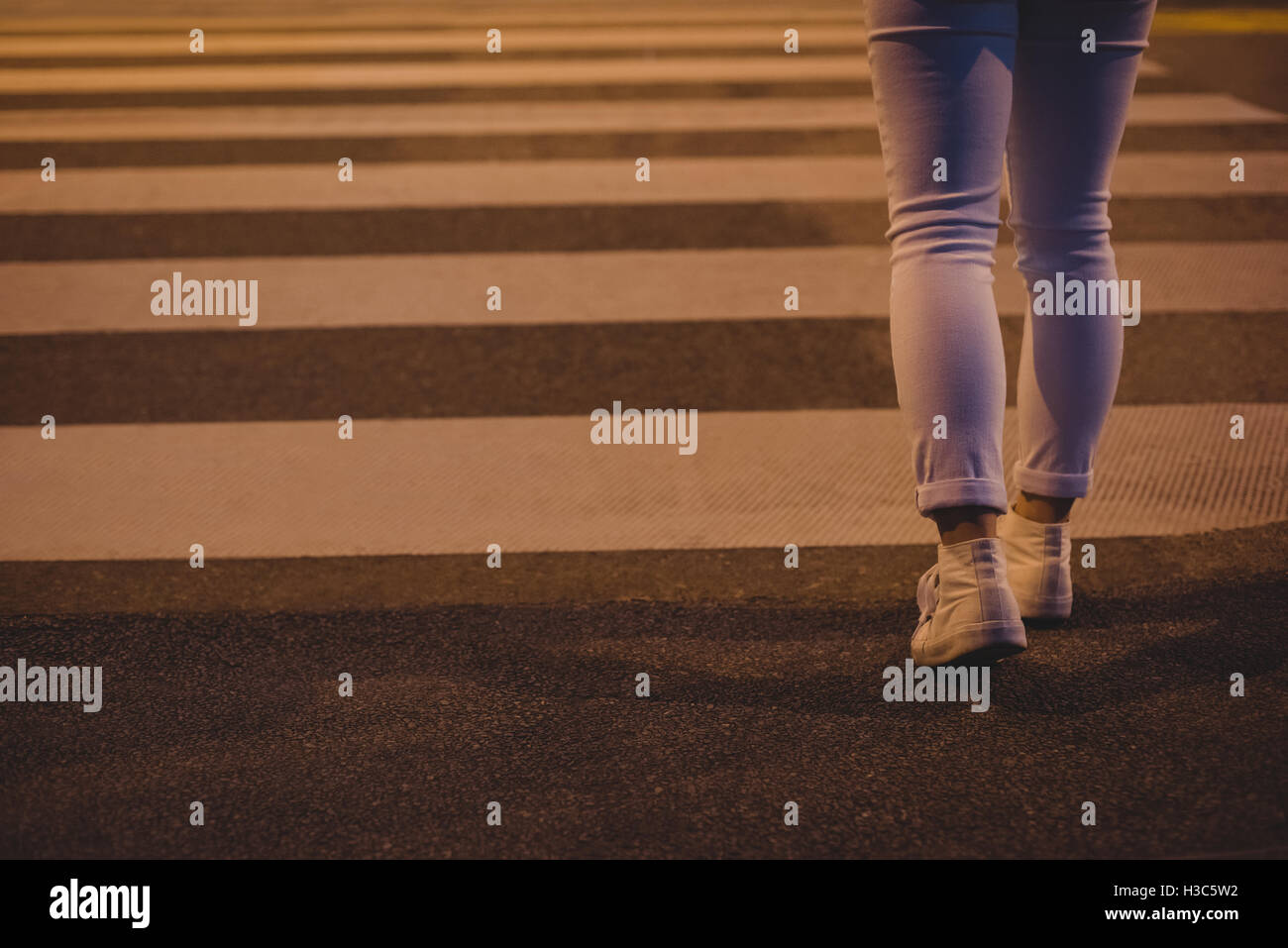 Woman walking on zebra crossing Stock Photo - Alamy