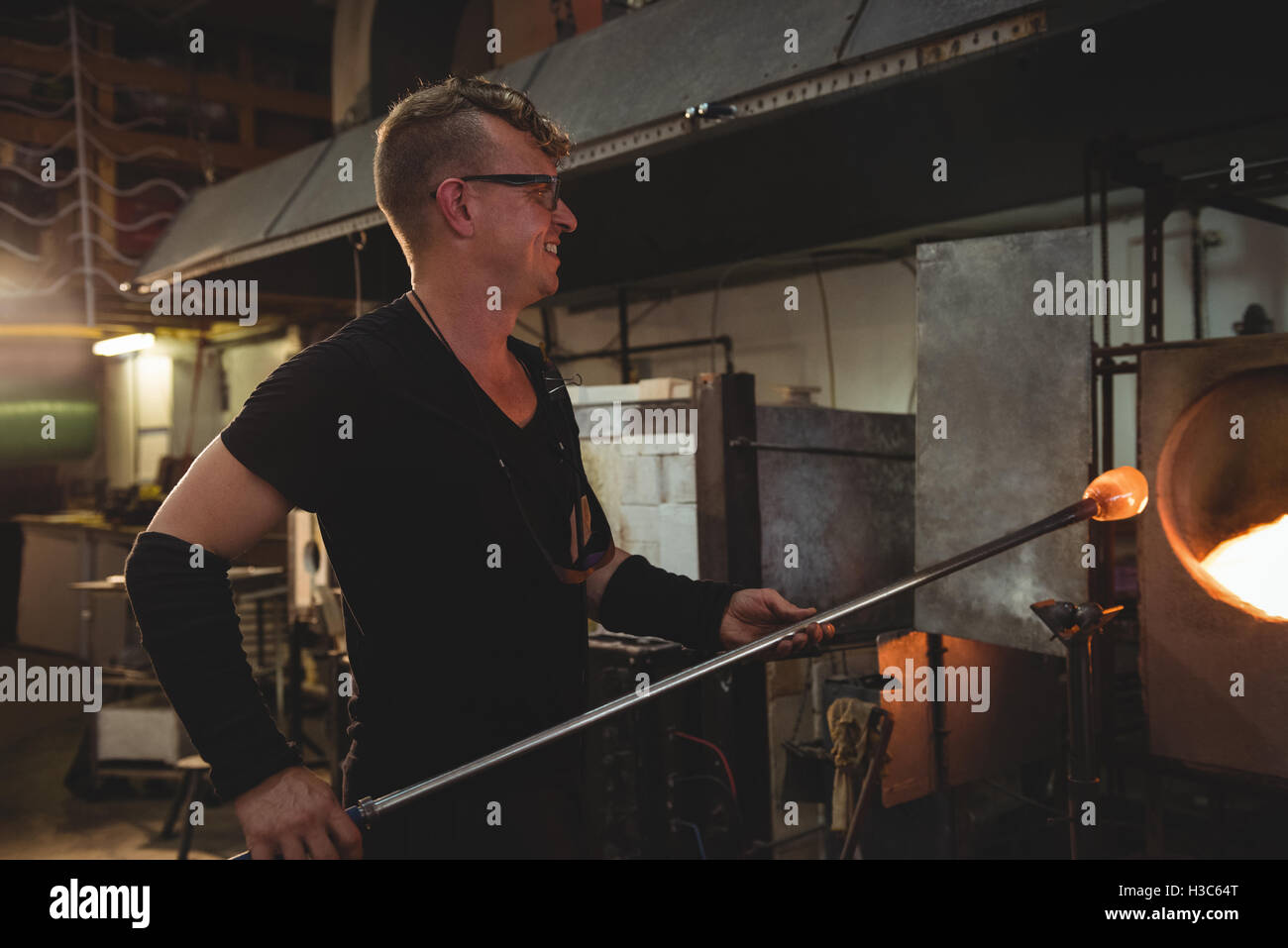 Glassblower heating a glass in furnace Stock Photo - Alamy