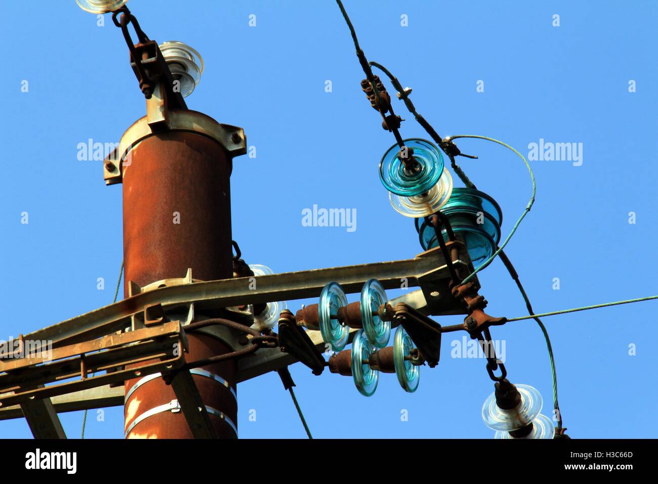 Old pylon Power in use, isolated in the blue summer sky Stock Photo - Alamy