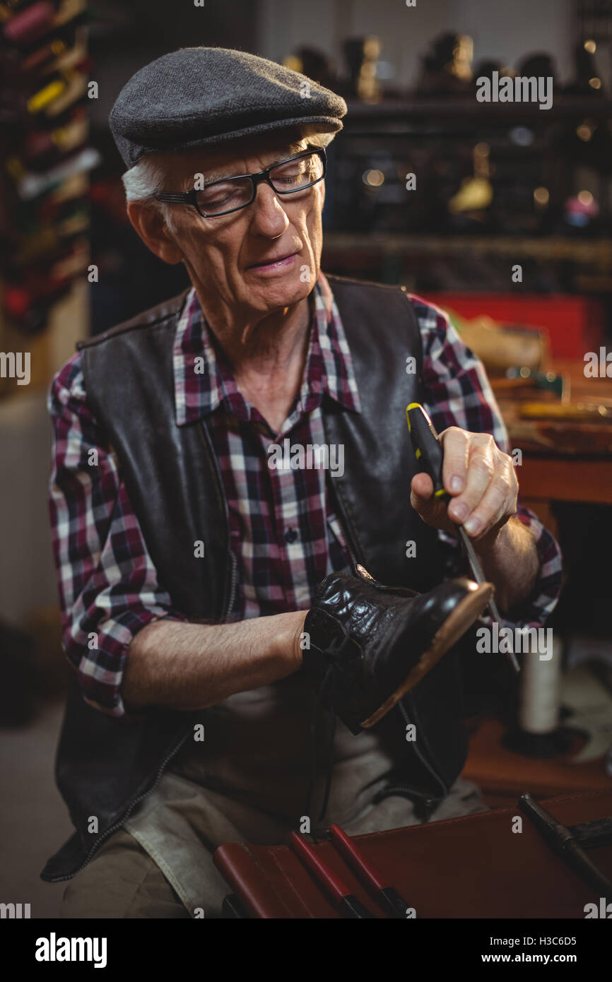 Shoemaker repairing a shoe Stock Photo - Alamy