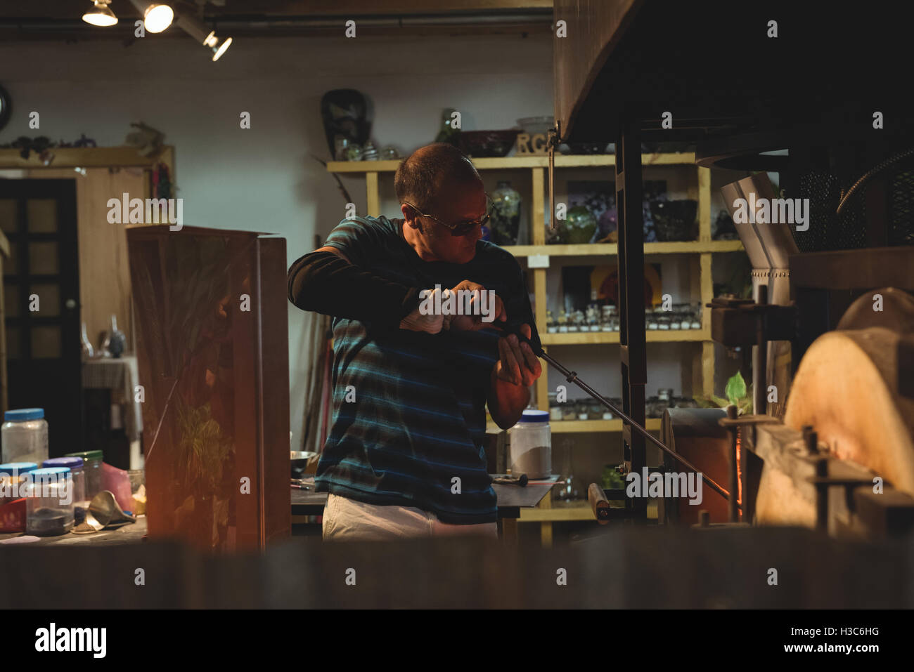 Glassblower heating a glass in furnace Stock Photo - Alamy