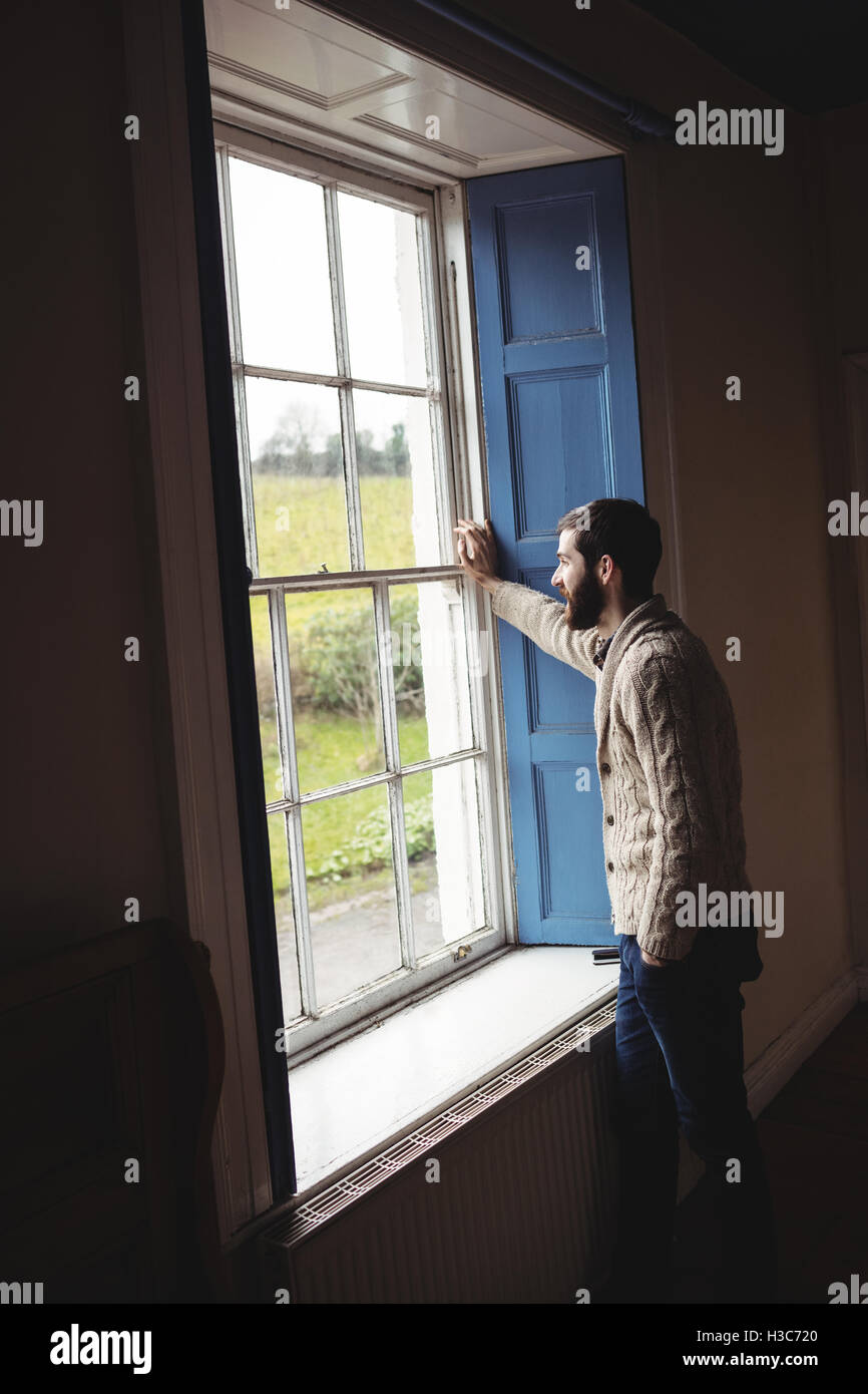 Man looking through window Stock Photo - Alamy