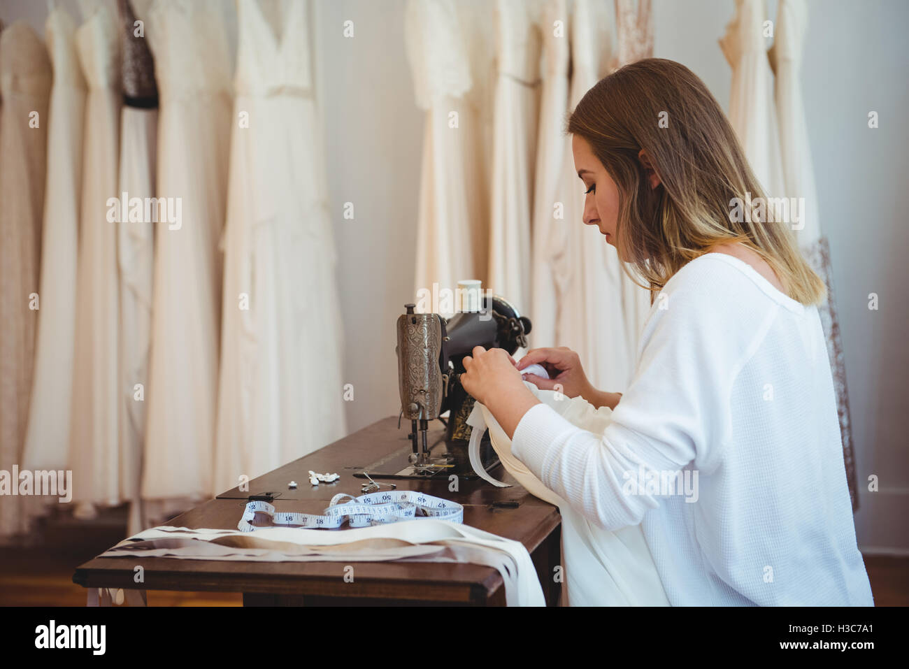 Beautiful female dressmaker sitting in hi-res stock photography and ...