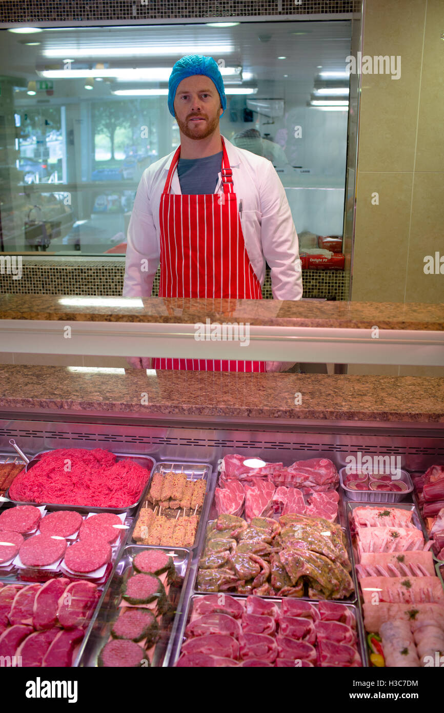 Portrait of butcher standing at meat counter Stock Photo - Alamy