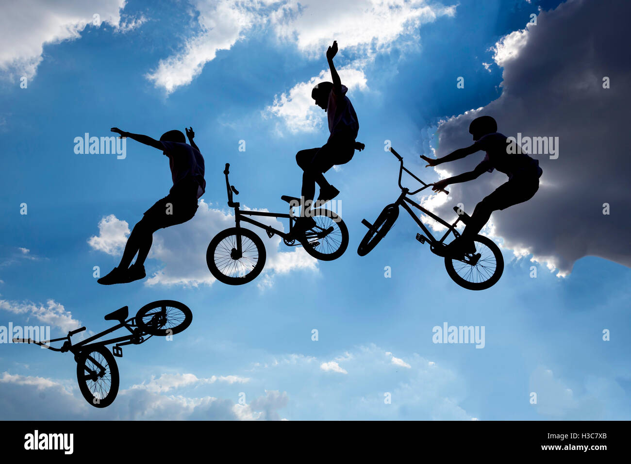 An extreme rider is making a free style jump from a ramp. The young boy ...