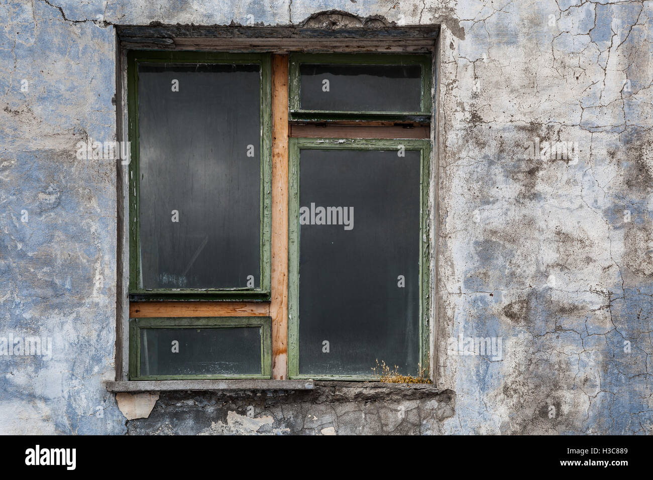 A broken window frame, panes intact, in a derelict building in the ...