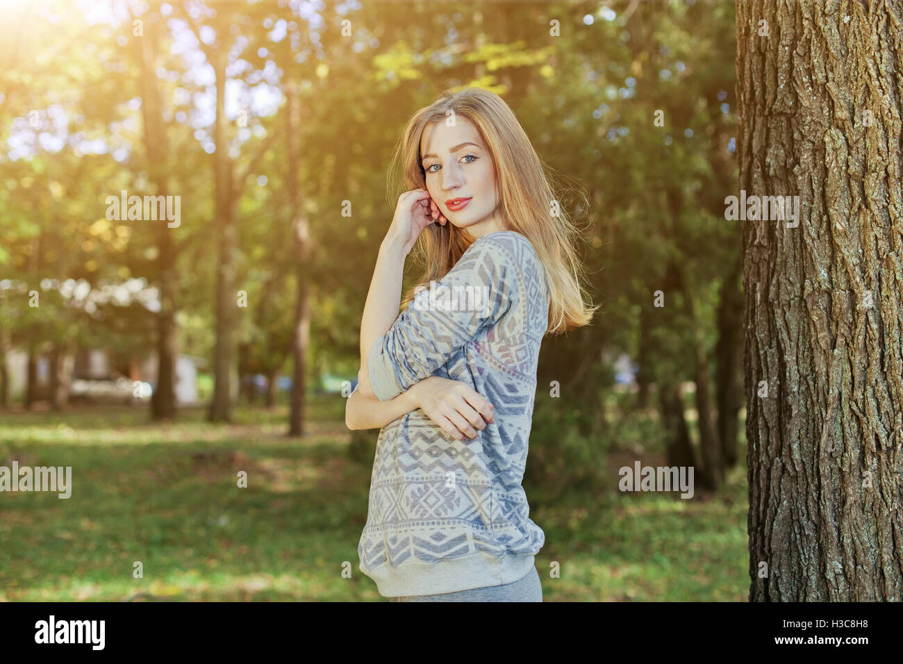 Beautiful elegant woman standing in a park in autumn Stock Photo - Alamy