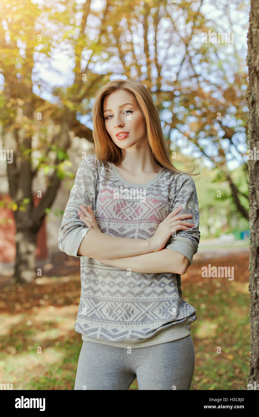 Beautiful elegant woman standing in a park in autumn Stock Photo - Alamy