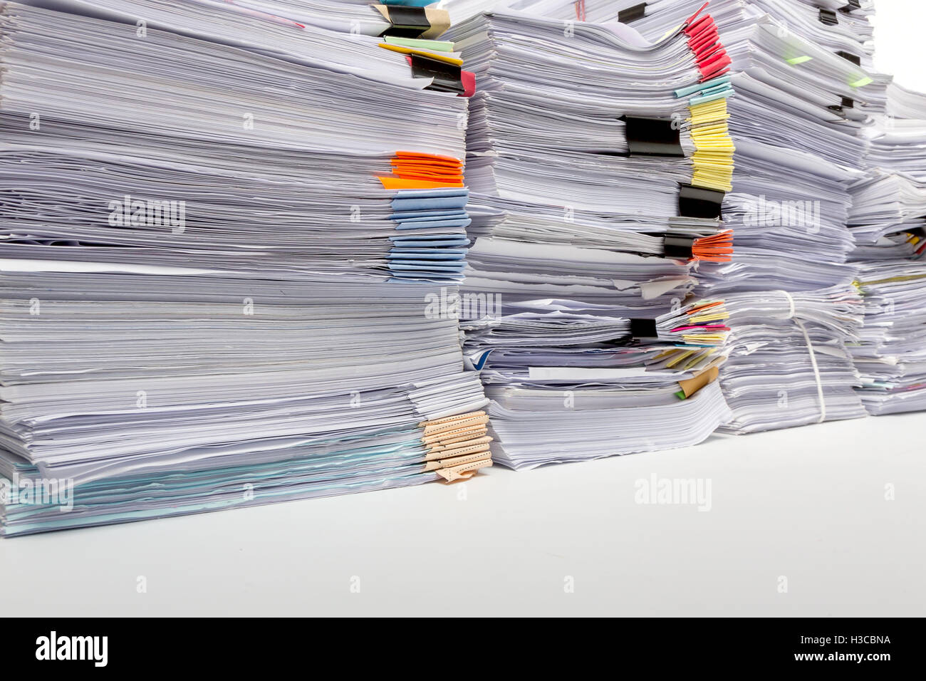 Business workload concept. Pile of unfinished business documents on ...