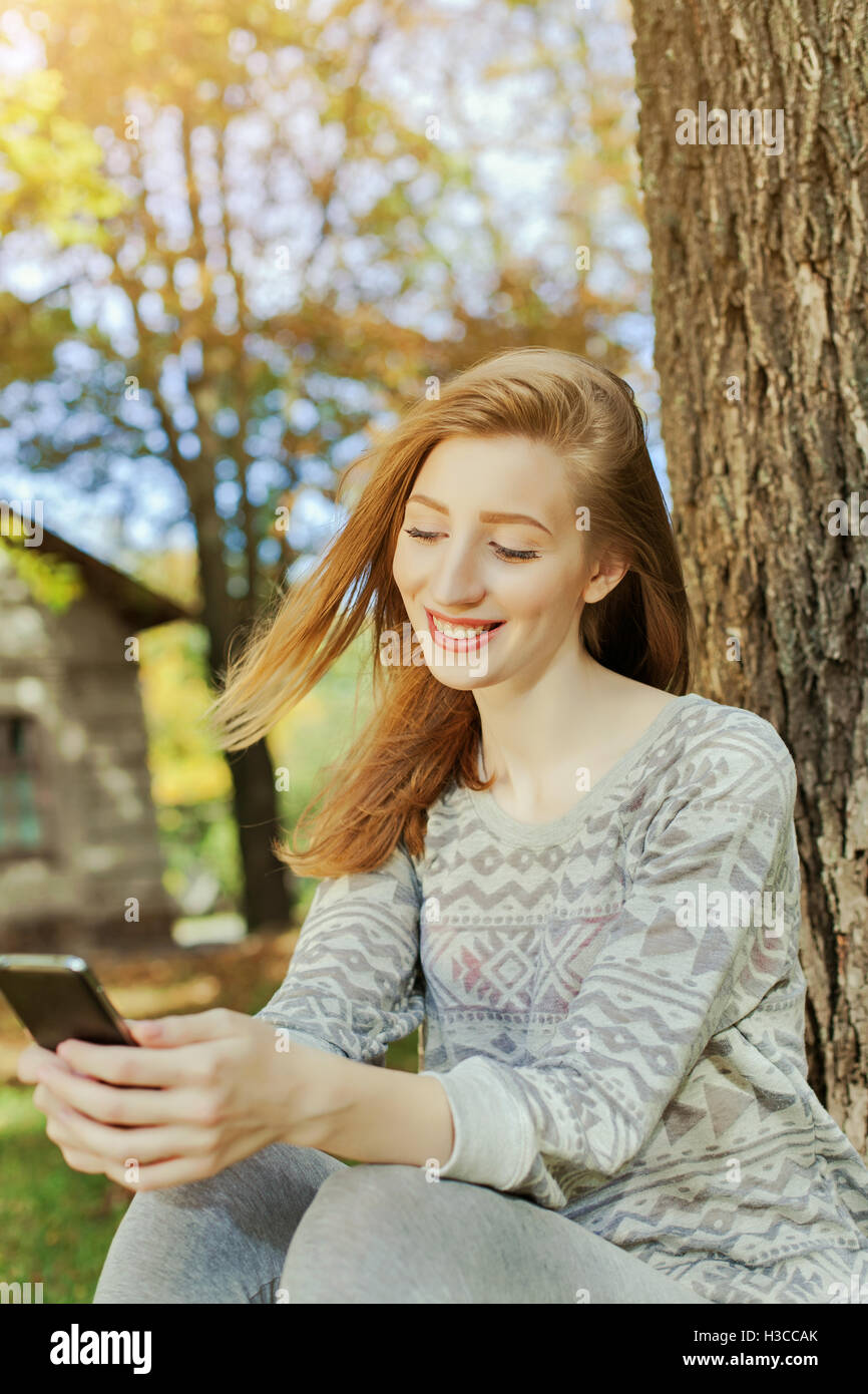 Beautiful girl looks on the phone Stock Photo - Alamy