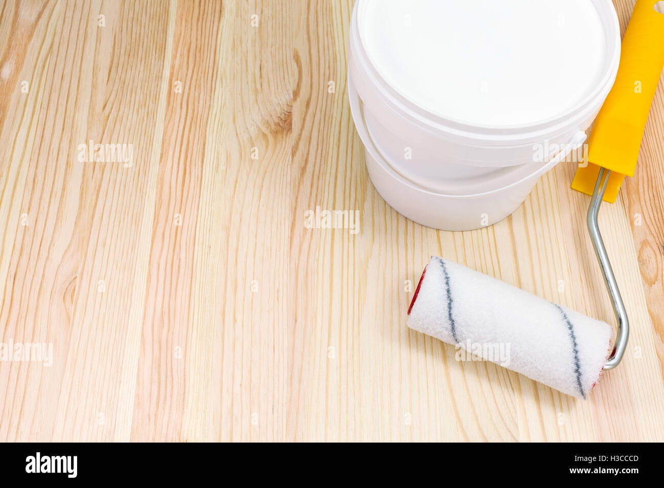 paint roller with paint bucket ready for use on wooden boards Stock ...