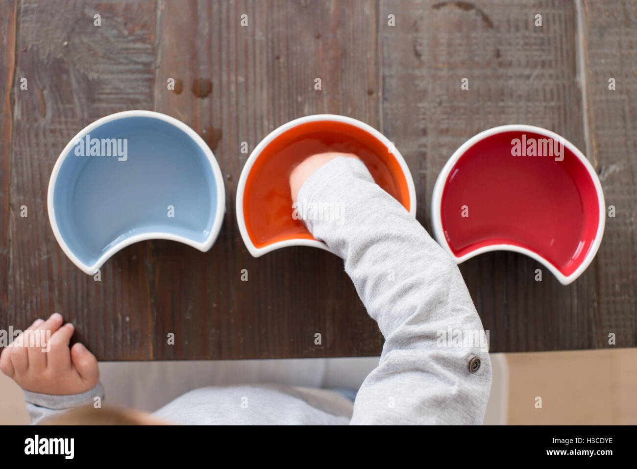 Child reaching into bowl, overhead view Stock Photo - Alamy