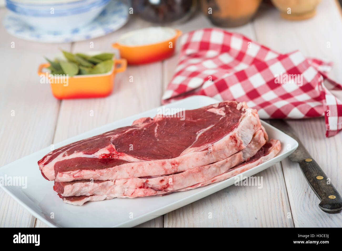 Raw steaks on the kitchen table ready to cook Stock Photo - Alamy