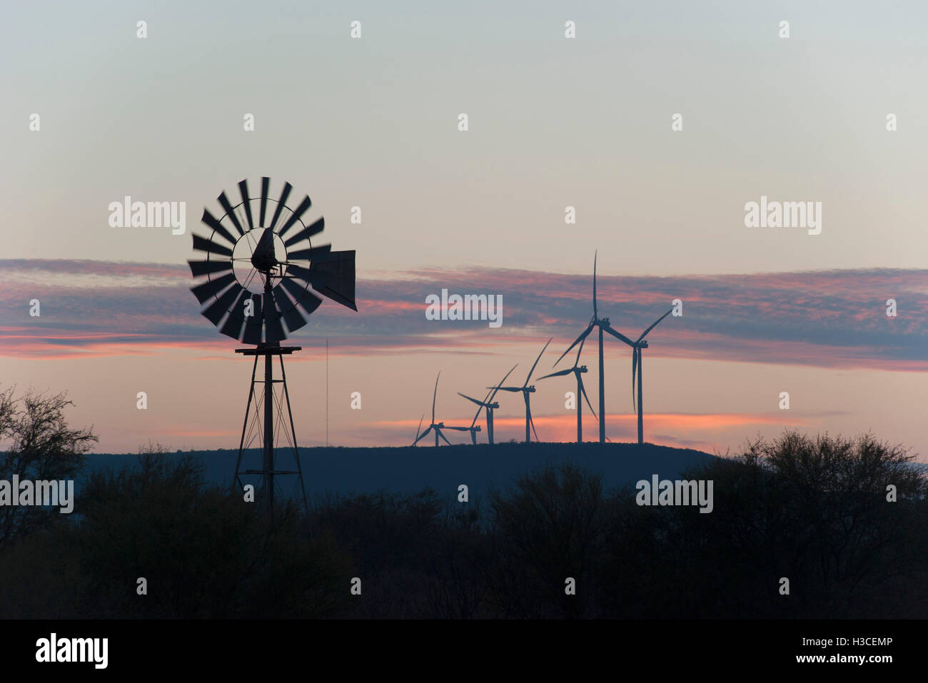 Tranquil view of an old-fashioned windmill and modern wind turbines ...