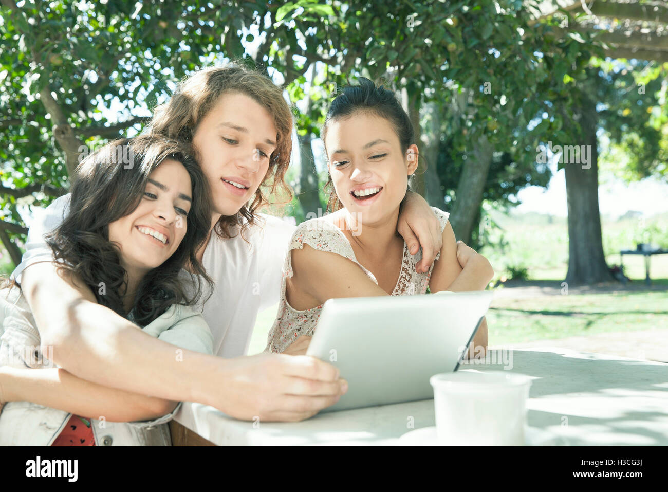 Young friends watching video on digital tablet together Stock Photo - Alamy