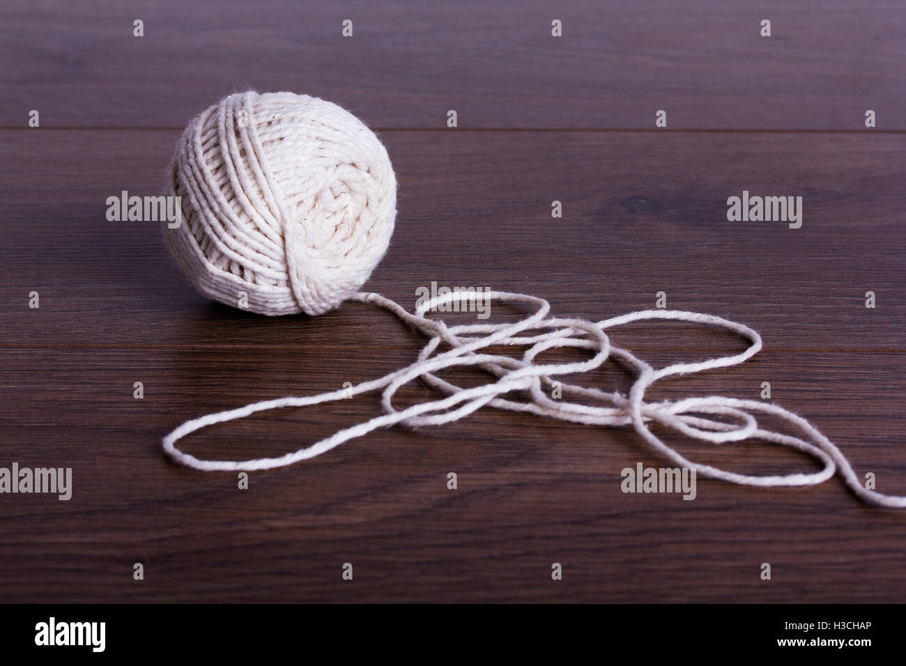 Ball of white string on a wooden background Stock Photo - Alamy
