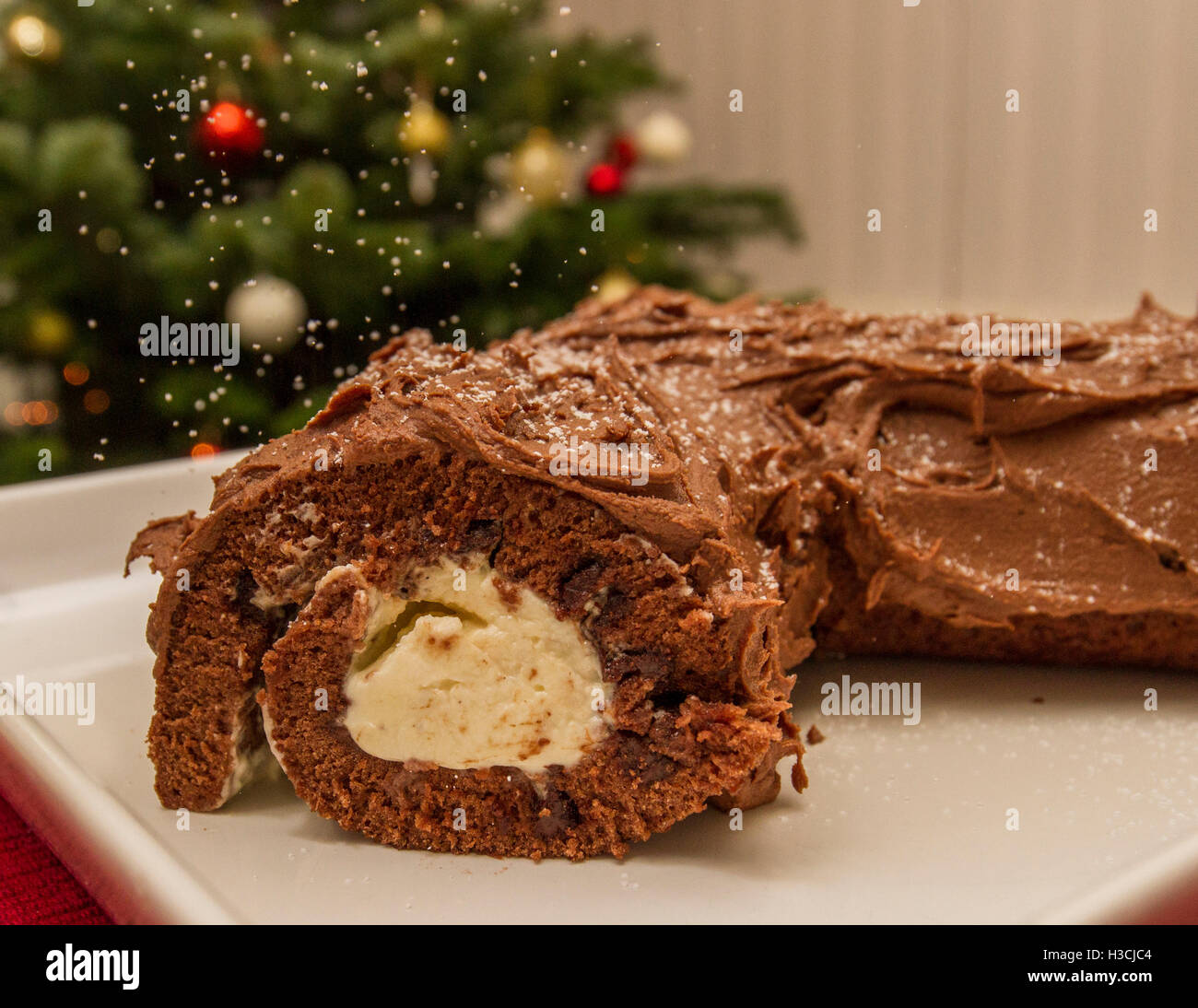 Christmas chocolate roulade dusted with icing sugar and decorated tree ...
