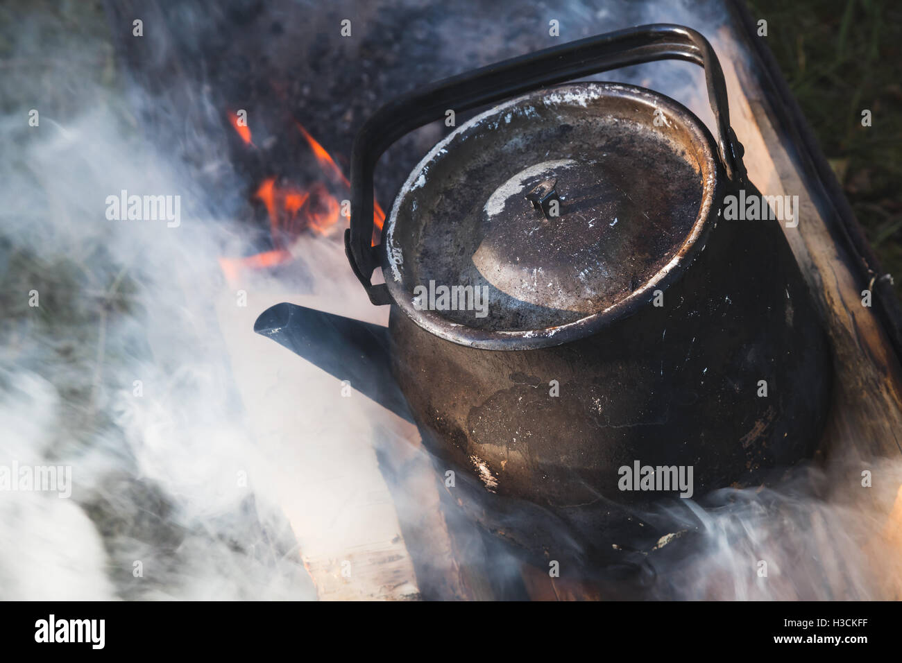 Old used black teapot with boiling water stands on a bonfire Stock ...
