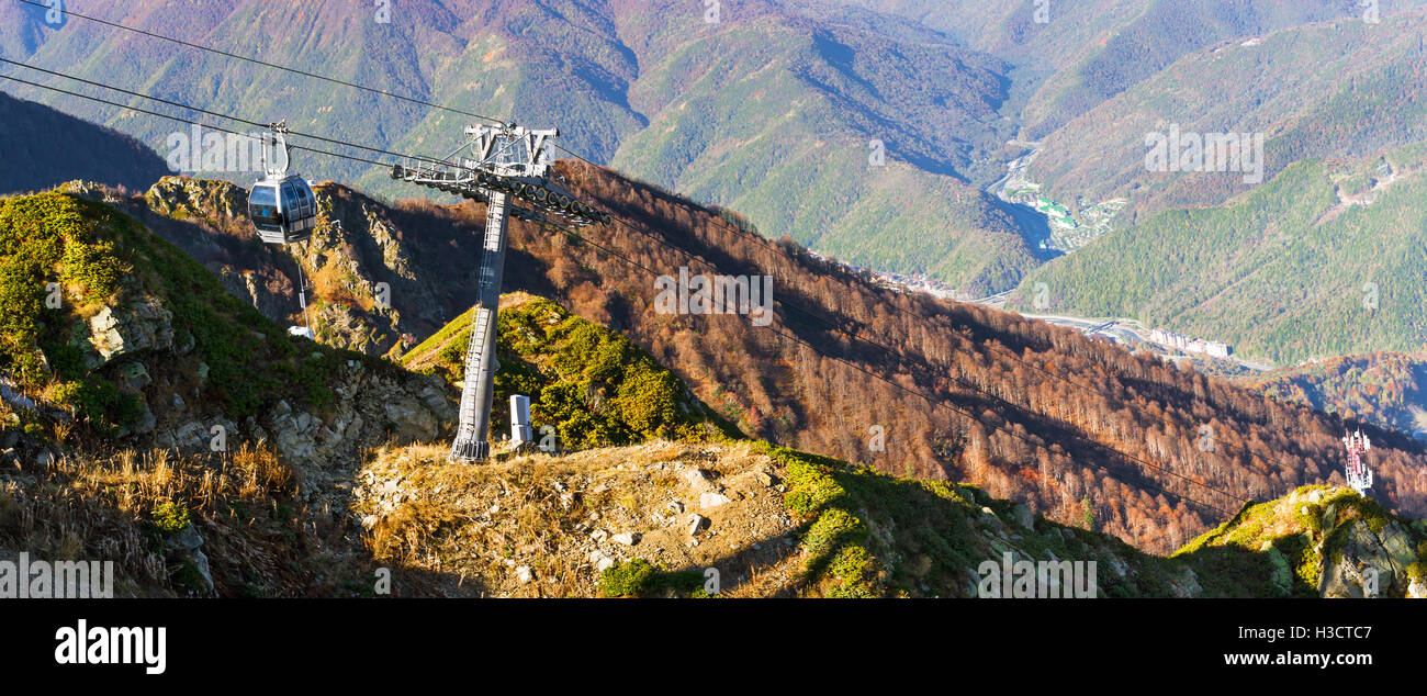 Mountain zipline through autumn forest on backdrop of Caucasus ...