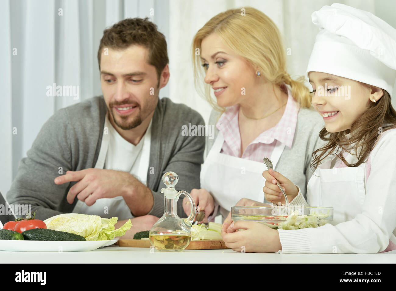 family with daughter cooking in kitchen Stock Photo - Alamy