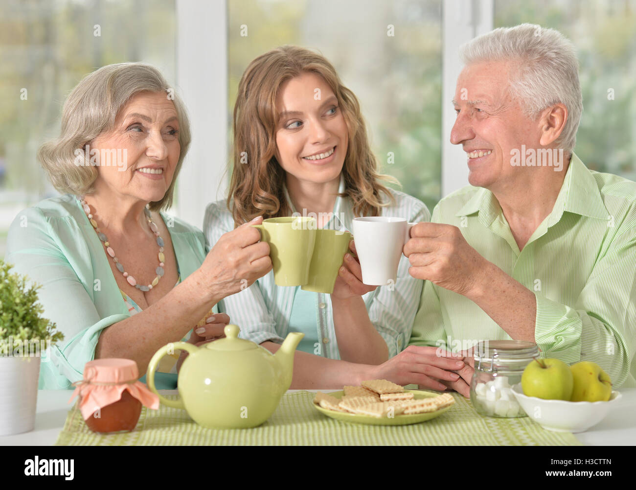 daughter with senior parents drinking tea Stock Photo - Alamy