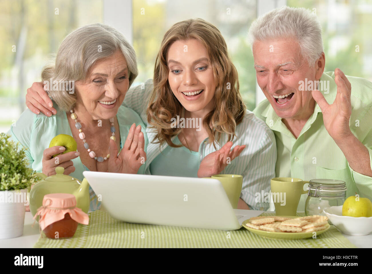 daughter with senior parents drinking tea Stock Photo - Alamy