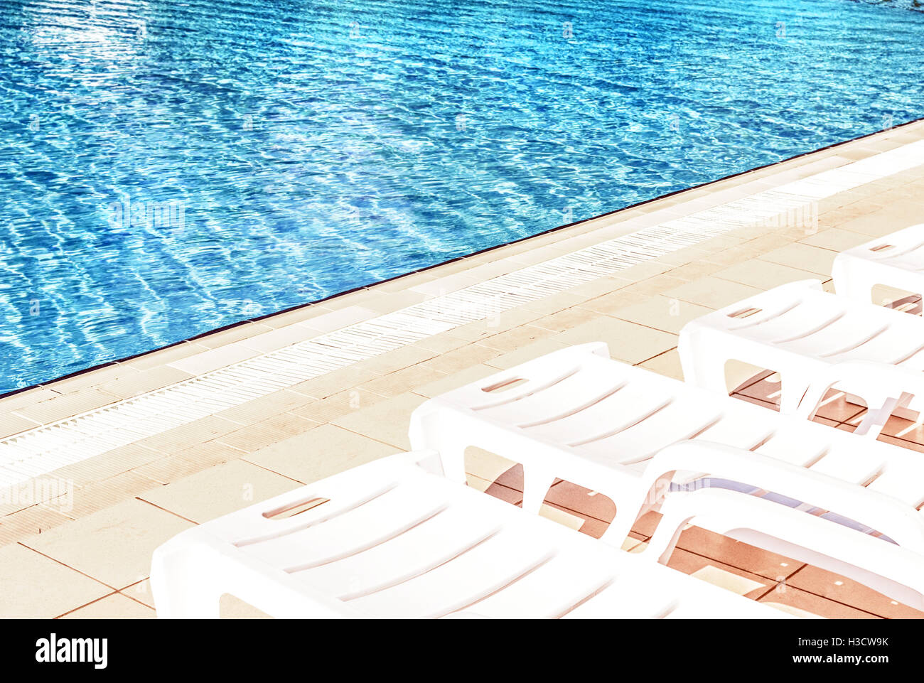 White plastic sunbeds at pool with blue water at sunny morning Stock ...