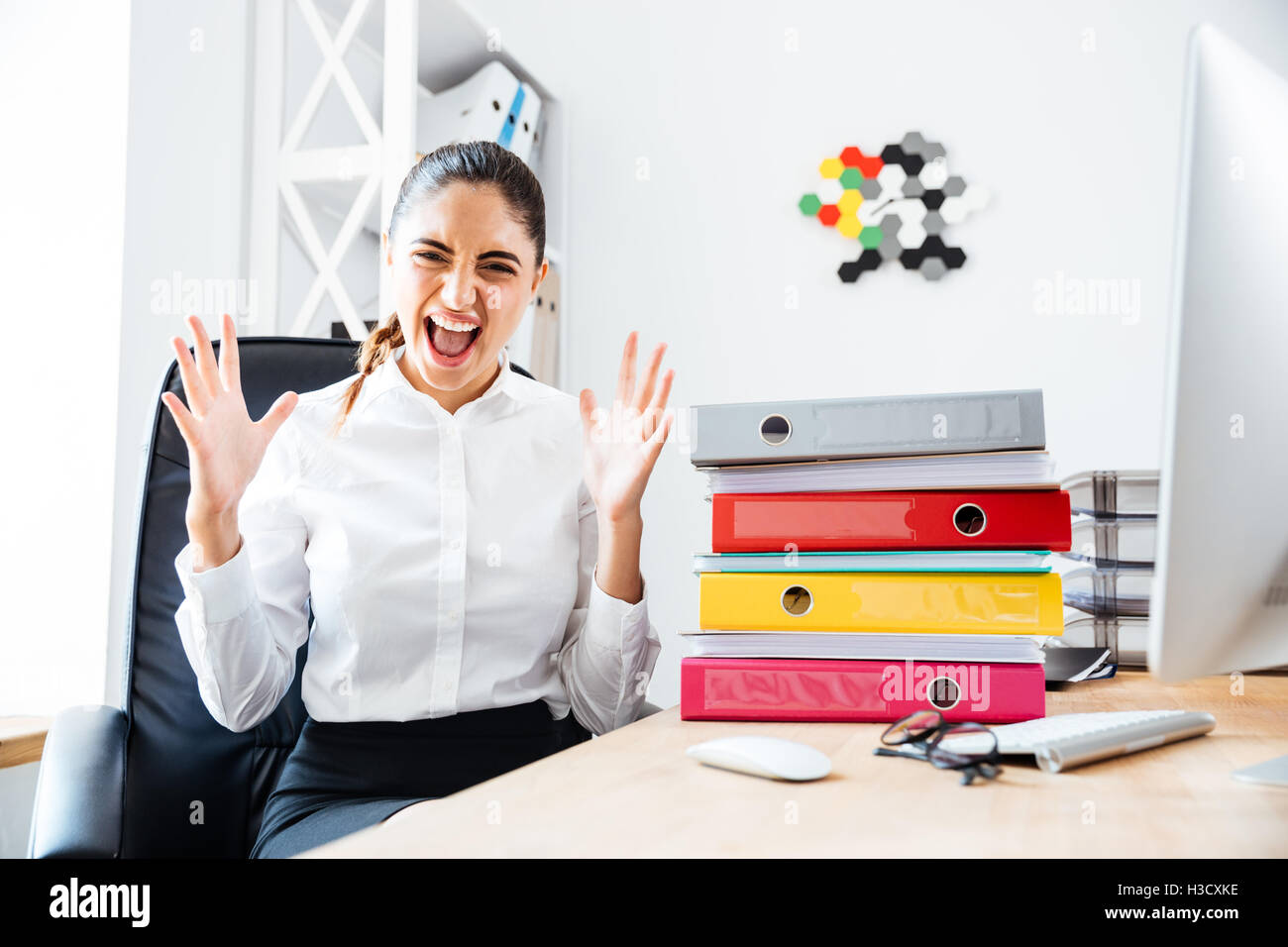 Angry crazy businesswoman screaming while sitting at workplace in ...