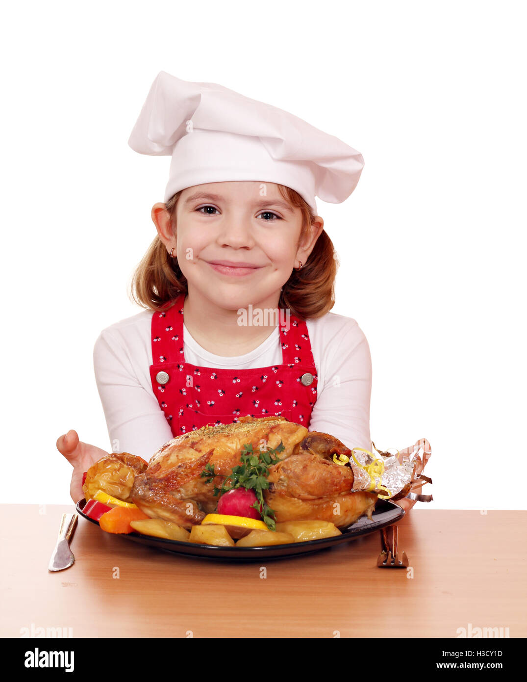 beautiful little girl cook with roasted chicken on table Stock Photo ...