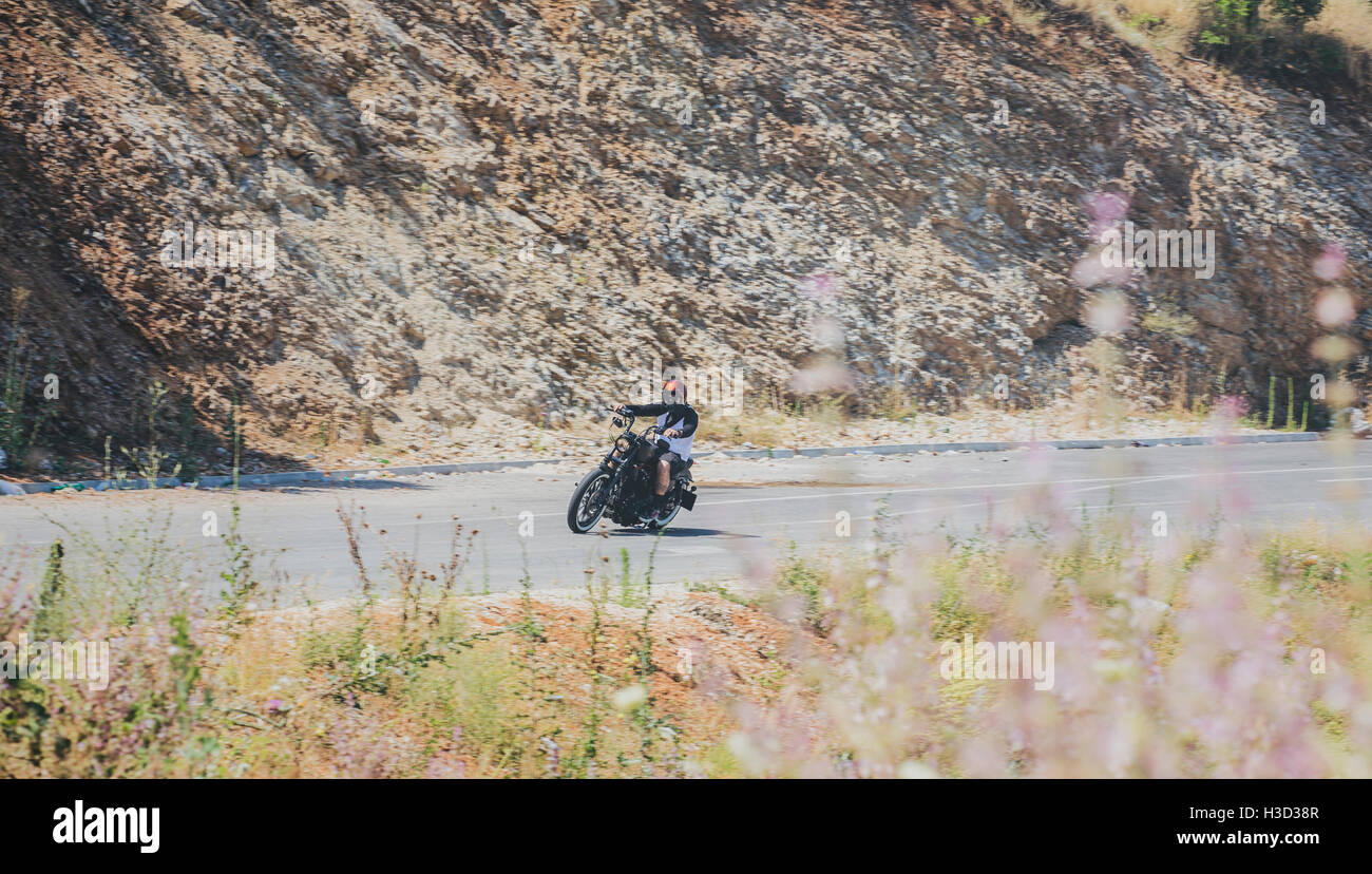 Biker riding cruiser motorcycle on road Stock Photo - Alamy