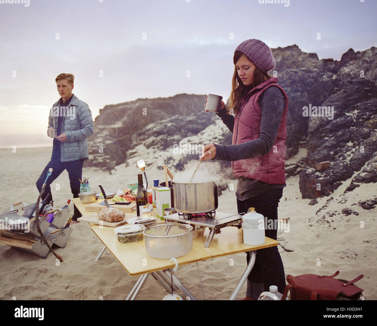 Woman cooking during vacation with friend at beach Stock Photo - Alamy