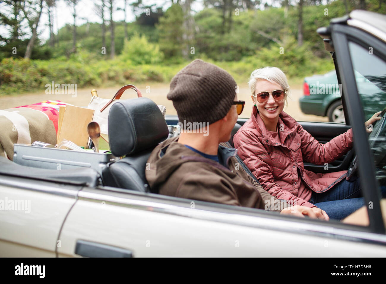 Happy woman sitting with man in convertible Stock Photo - Alamy