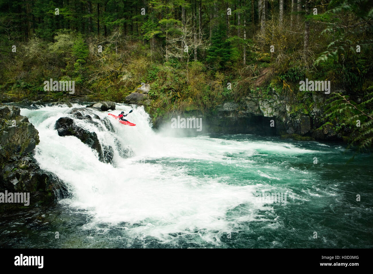 Man kayaking over waterfall in forest Stock Photo - Alamy