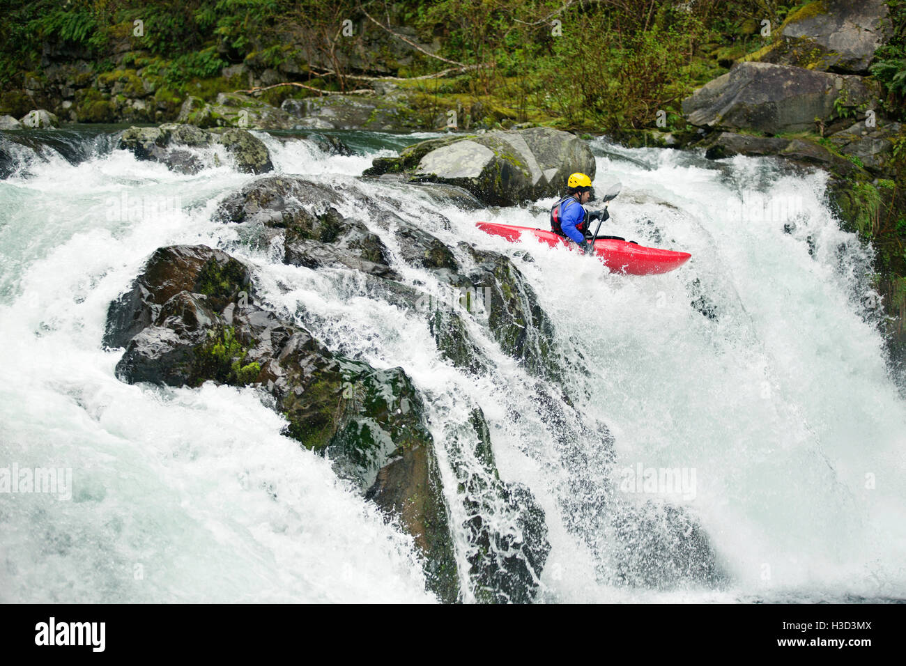 Kayaker paddling through waterfall in forest Stock Photo - Alamy