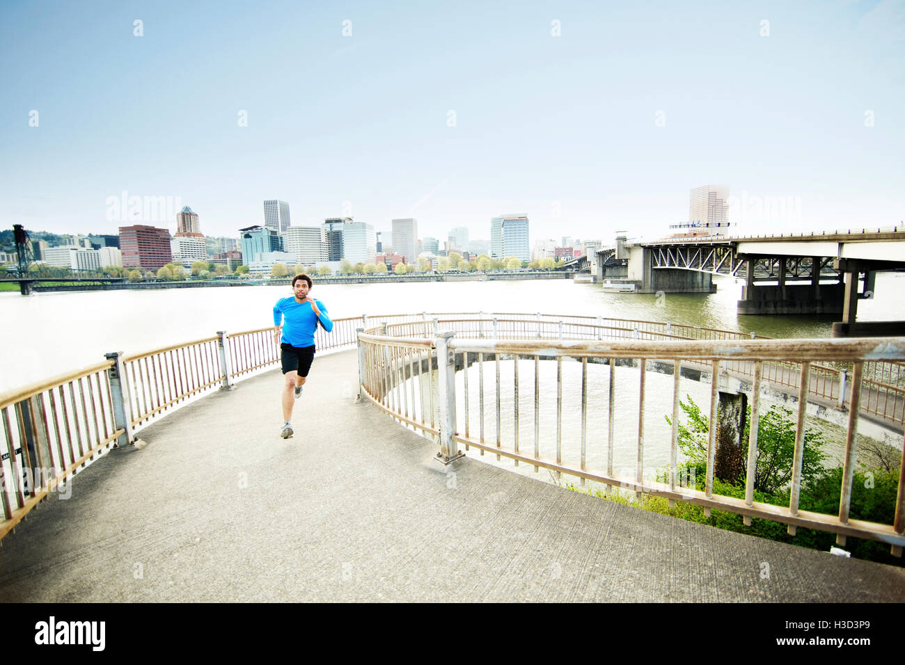 Man running on bridge by river against clear sky Stock Photo - Alamy