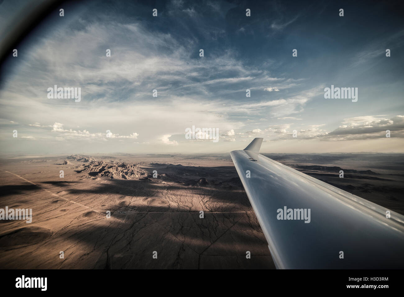 Cropped image of aircraft wing flying over landscape Stock Photo - Alamy