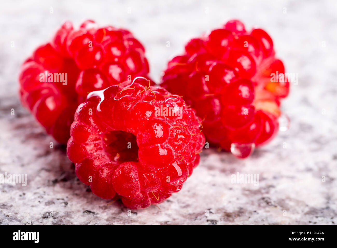 Close-up of wet raspberry on marble Stock Photo - Alamy