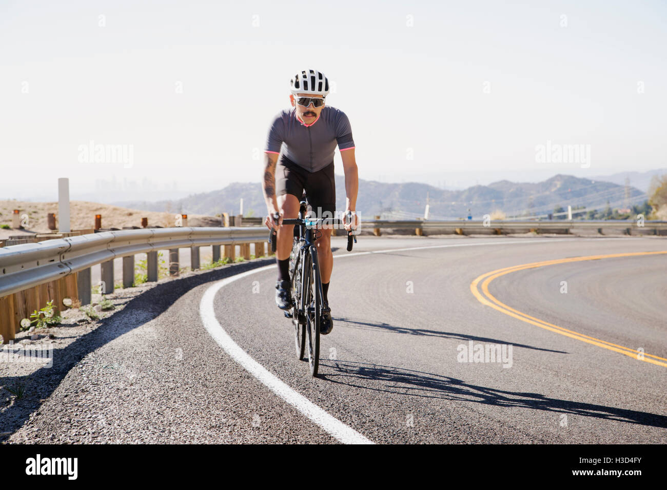 Man cycling on road against clear sky Stock Photo - Alamy