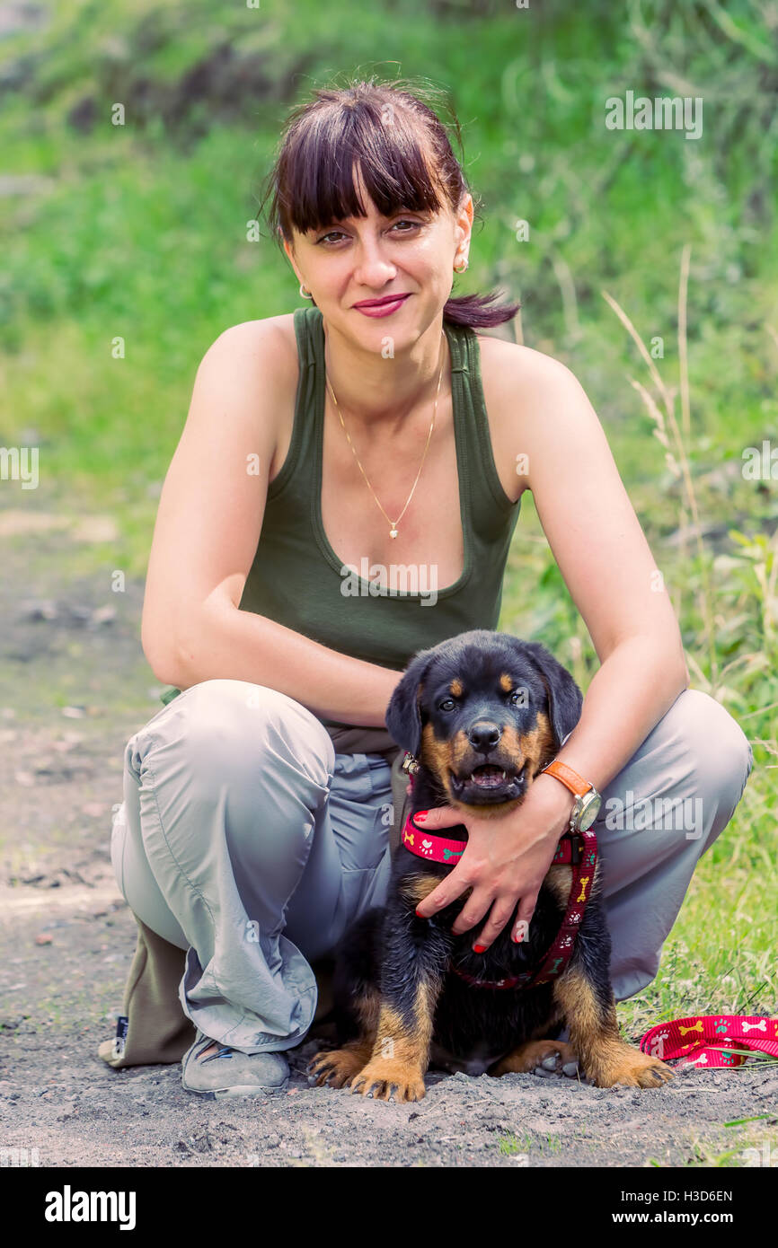 Portrait Of A Young Woman With His Rottweiler Puppy Stock Photo - Alamy
