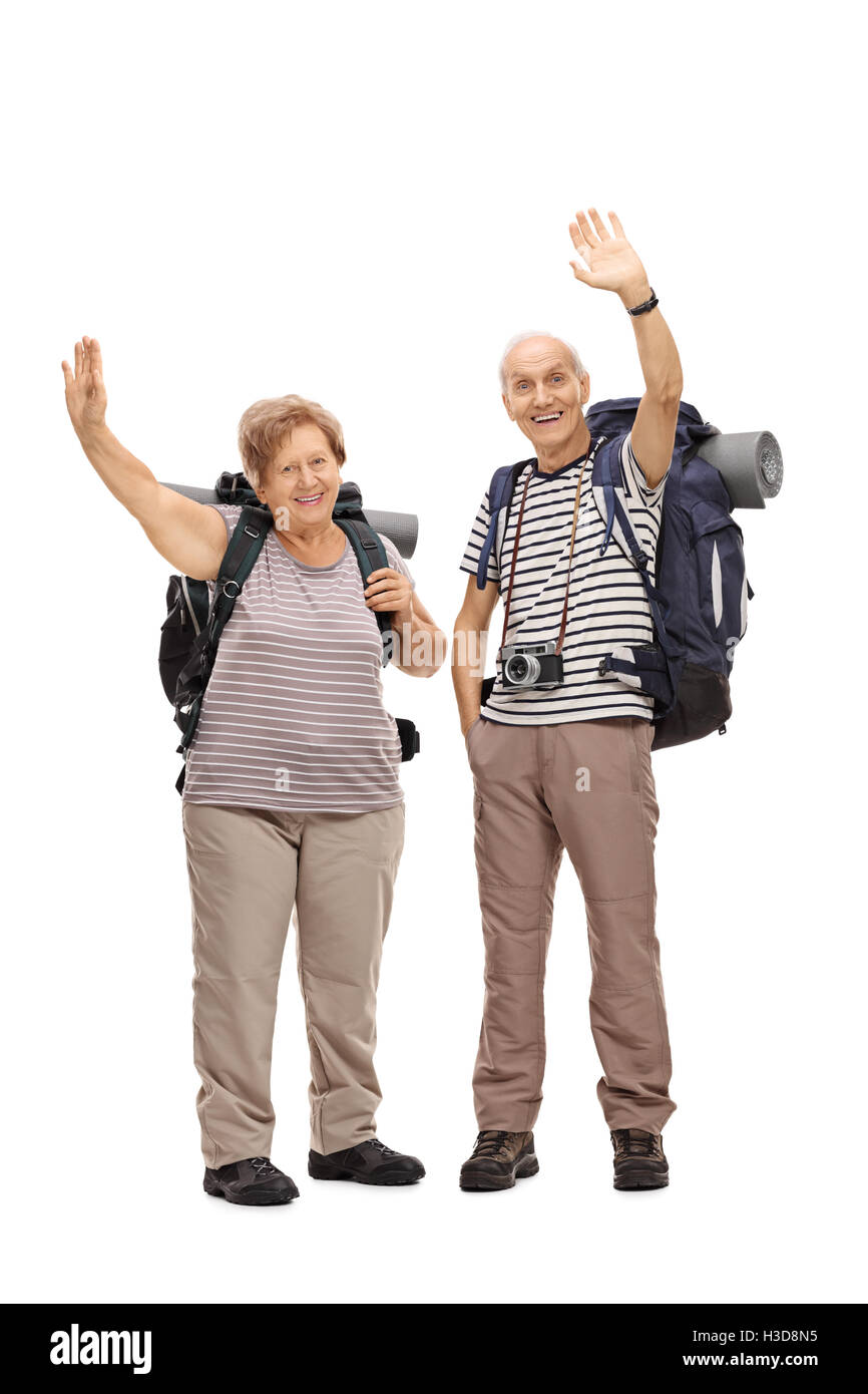 Full length portrait of two senior hikers waving at the camera isolated ...