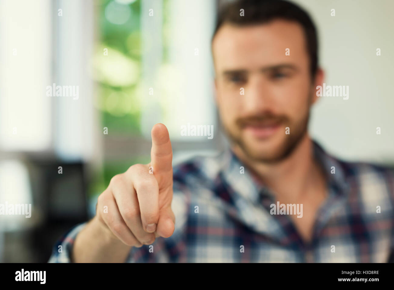 Male hand pushing a digital screen at modern office space background ...