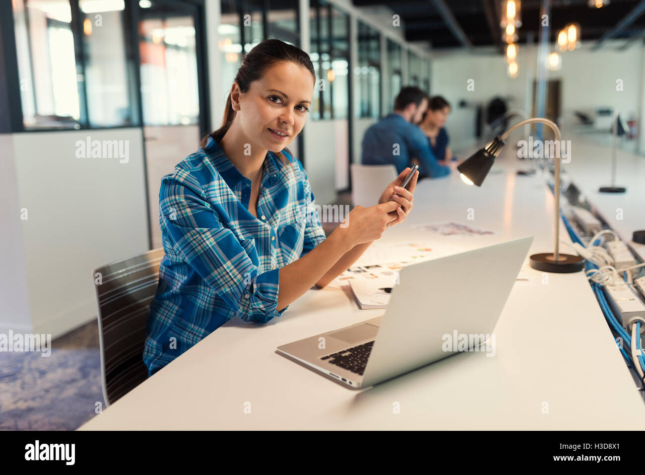 Portrait of casual cute woman in modern office coworking. Looking at ...