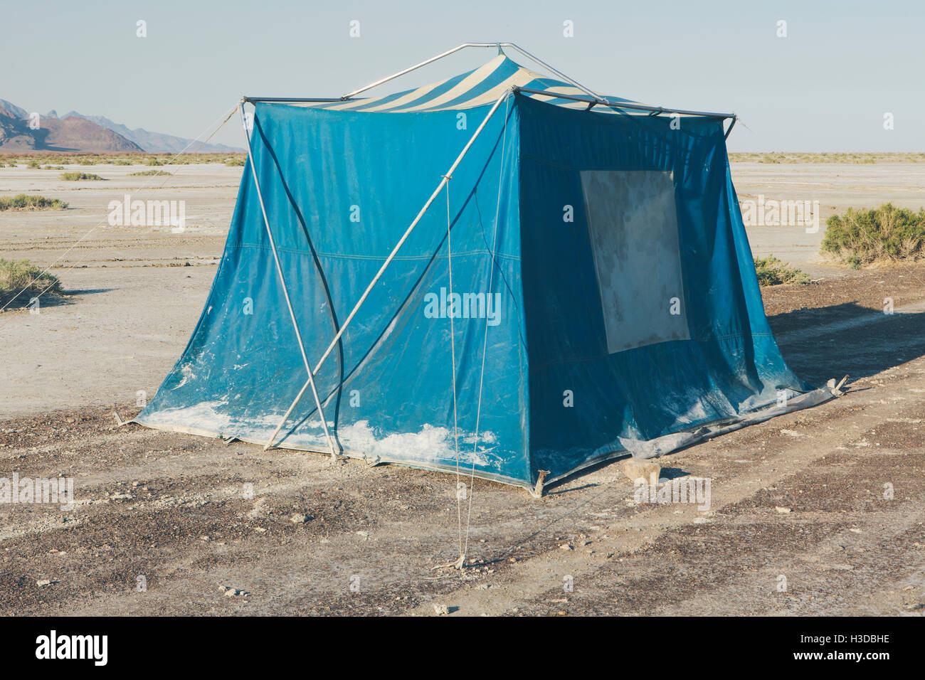 Old muddy blue camping tent in the desert of the Bonneville Salt Flats ...