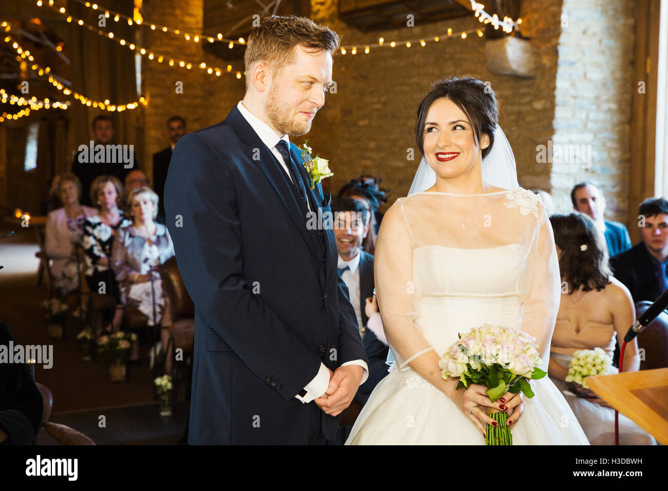 A bride and groom at their wedding ceremony, standing side by side in ...